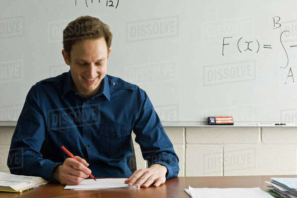 Teacher marking homework - Royalty-free Stock Photo | Dissolve