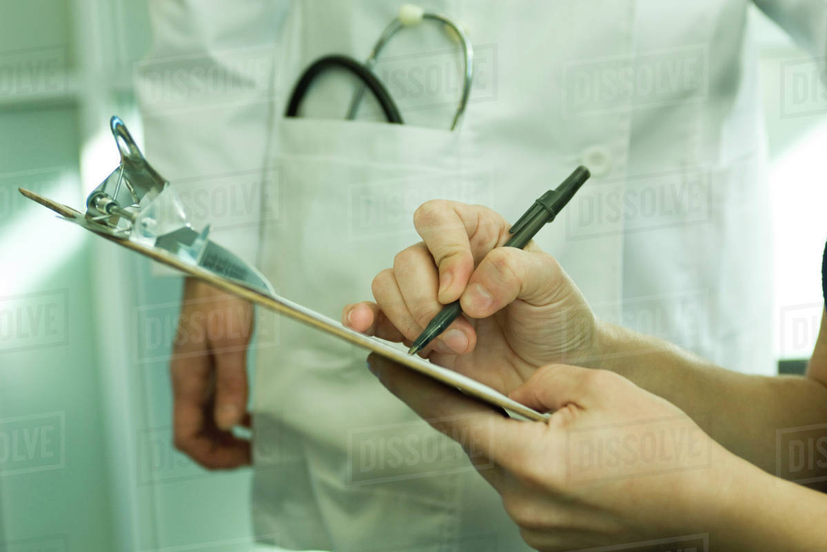 Patient completing medical paperwork - Royalty-free Stock Photo | Dissolve
