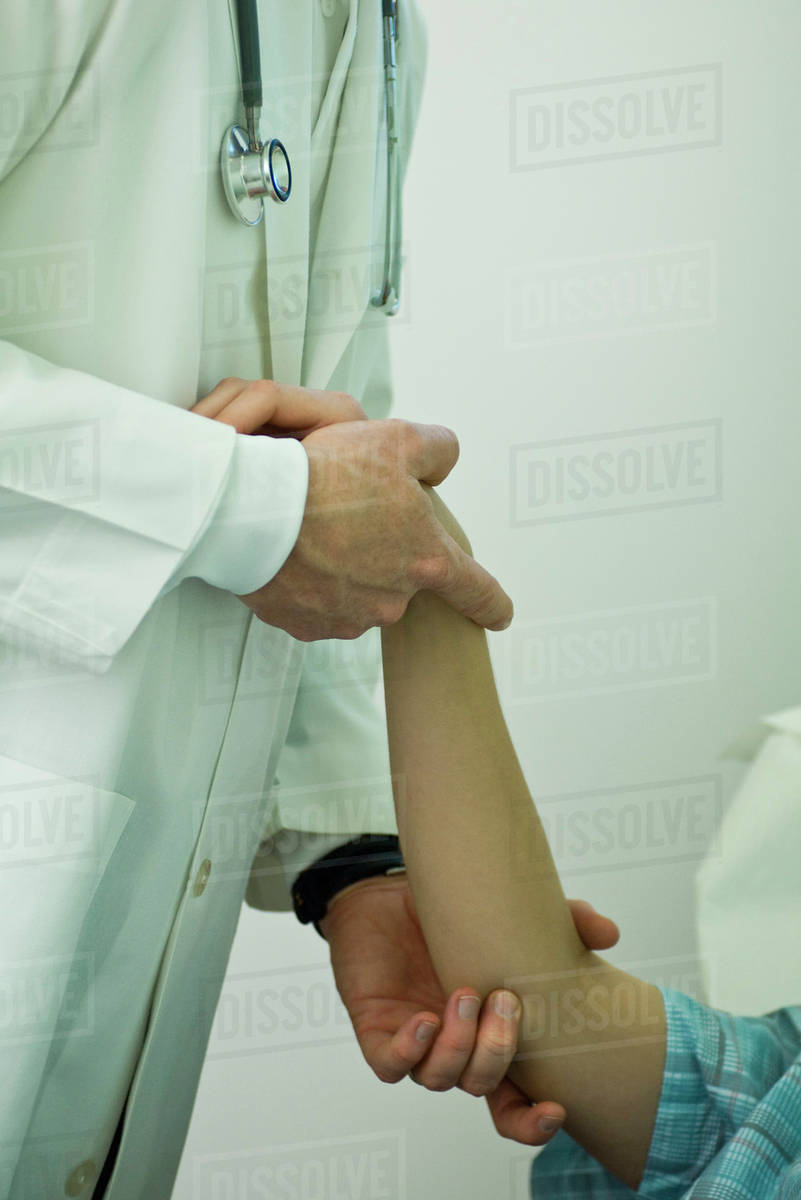 Doctor examining patient's arm - Royalty-free Stock Photo | Dissolve