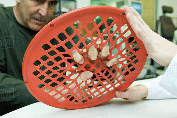 Patient using hand exercise web for occupational therapy treatment ...