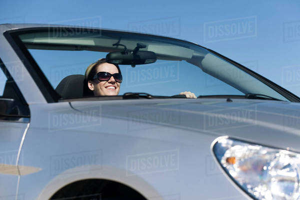 Woman enjoying pleasure drive on sunny day - Stock Photo - Dissolve