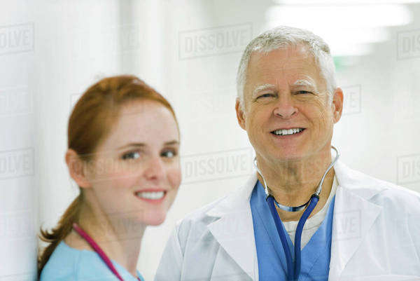 Doctor and nurse smiling, portrait - Stock Photo - Dissolve