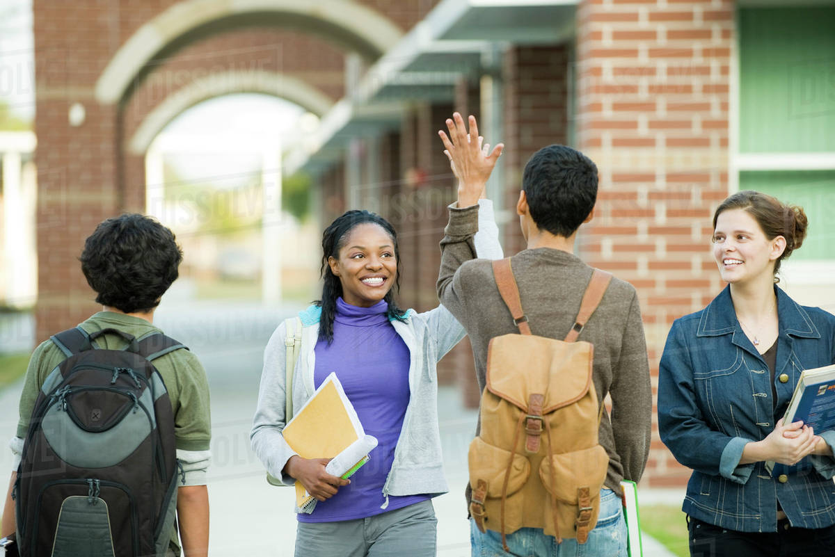 Classmates giving each other high-five - Stock Photo - Dissolve