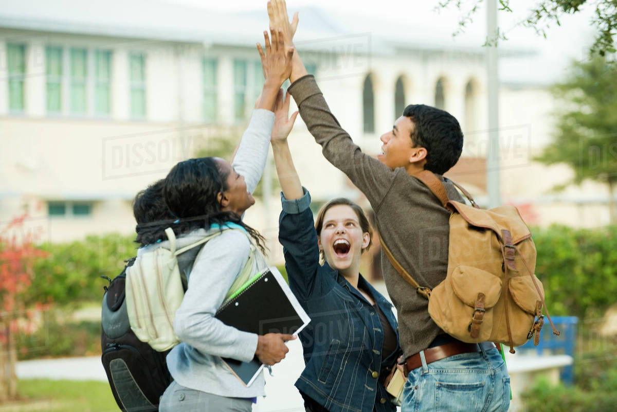 Classmates doing group high-five - Stock Photo - Dissolve