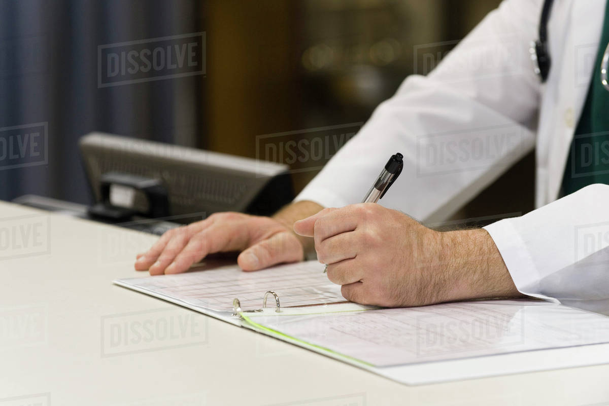 Healthcare worker completing document - Stock Photo - Dissolve