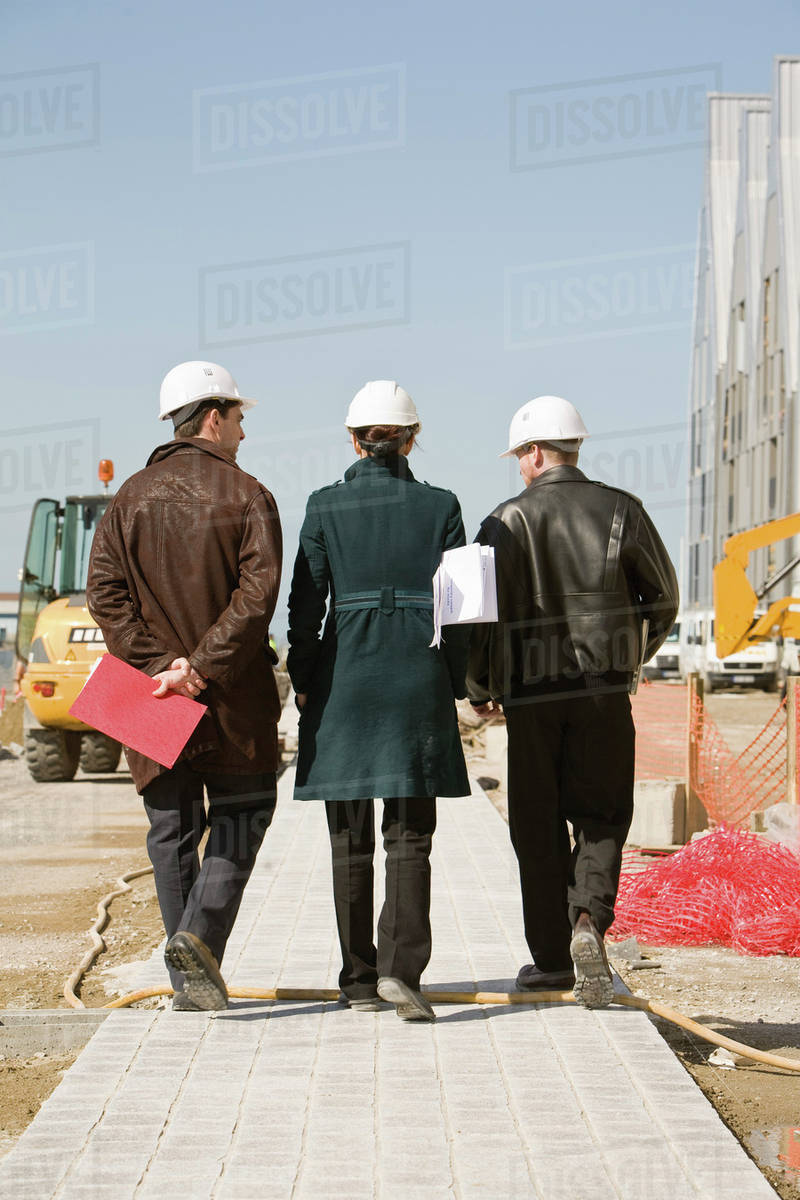 Property developers walking at construction site, rear view - Stock ...