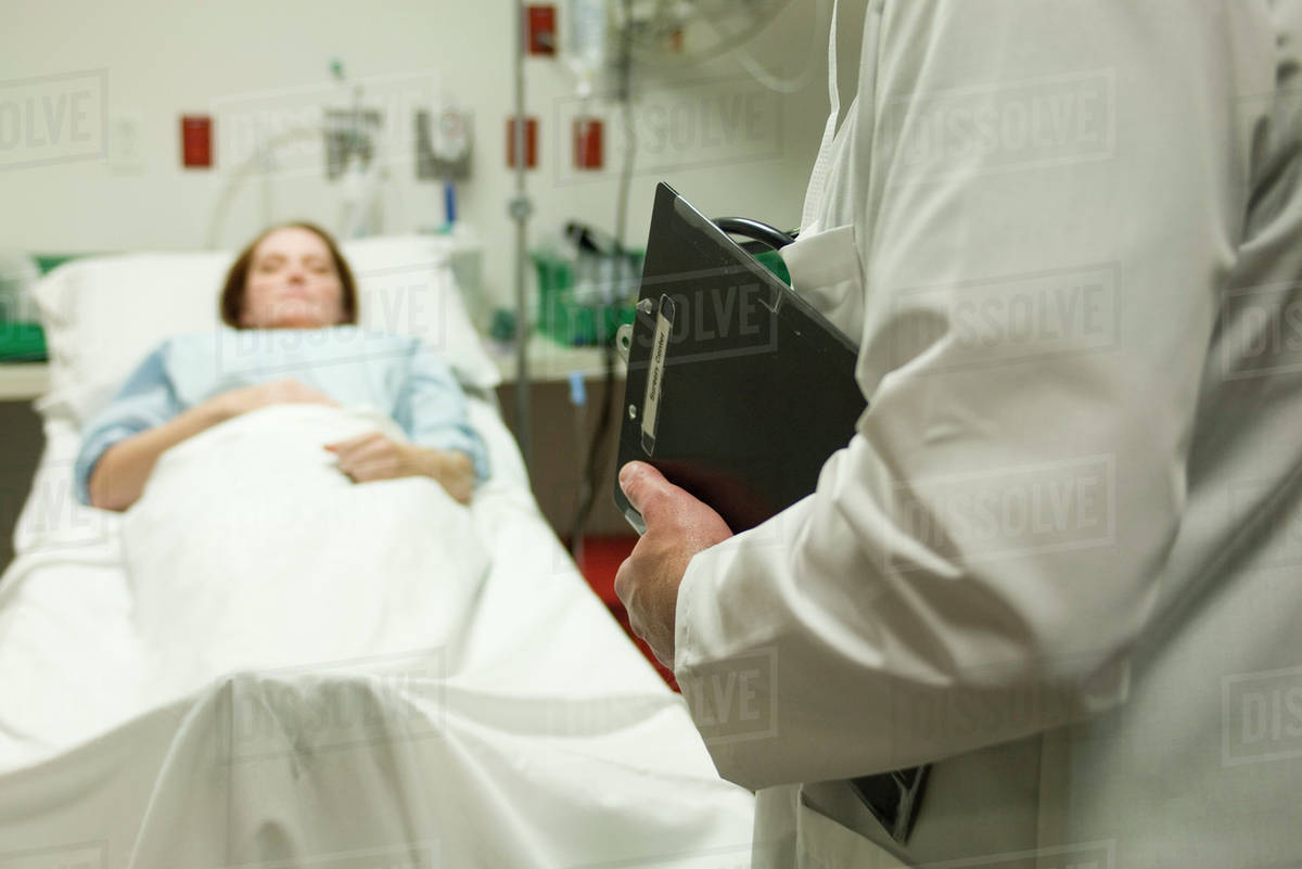 Doctor monitoring patient in hospital - Stock Photo - Dissolve