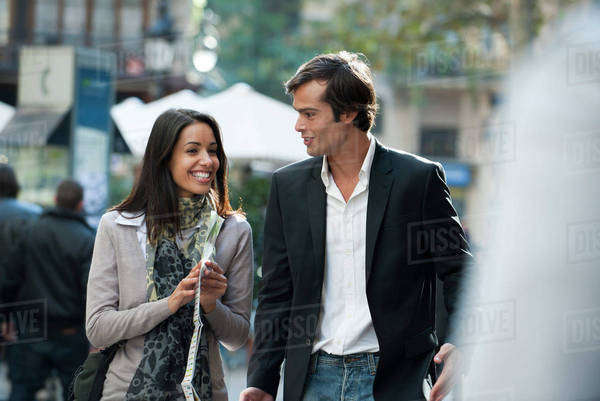 Couple walking and talking together outdoors - Stock Photo - Dissolve