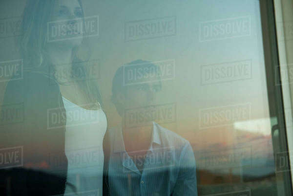 Couple looking through window - Stock Photo - Dissolve