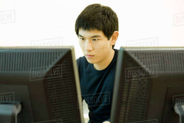 Young man working on computer with two monitors - Royalty-free Stock ...