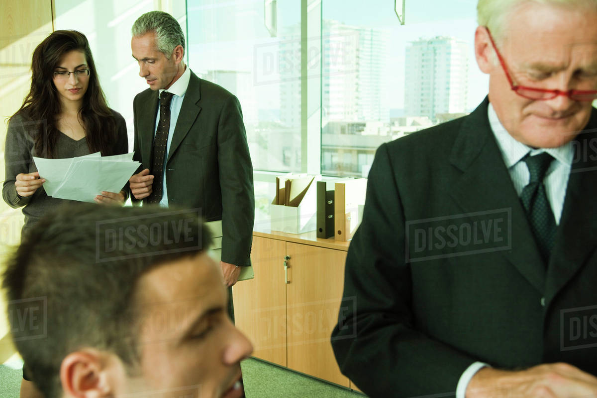 Executives working with young associates in office - Royalty-free Stock ...