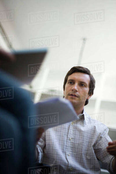 Men reviewing document - Stock Photo - Dissolve