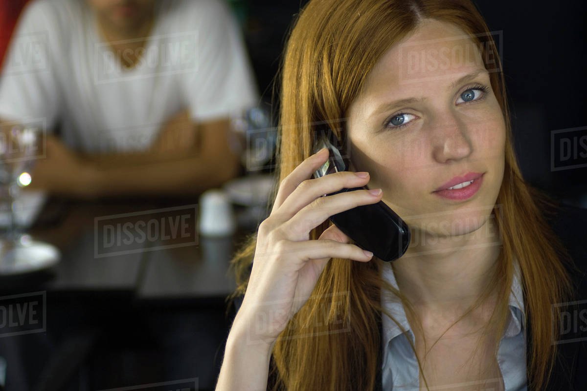 Woman holding cell phone to ear, smiling at camera - Royalty-free Stock ...