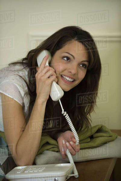 Young woman using landline phone, smiling - Royalty-free Stock Photo ...