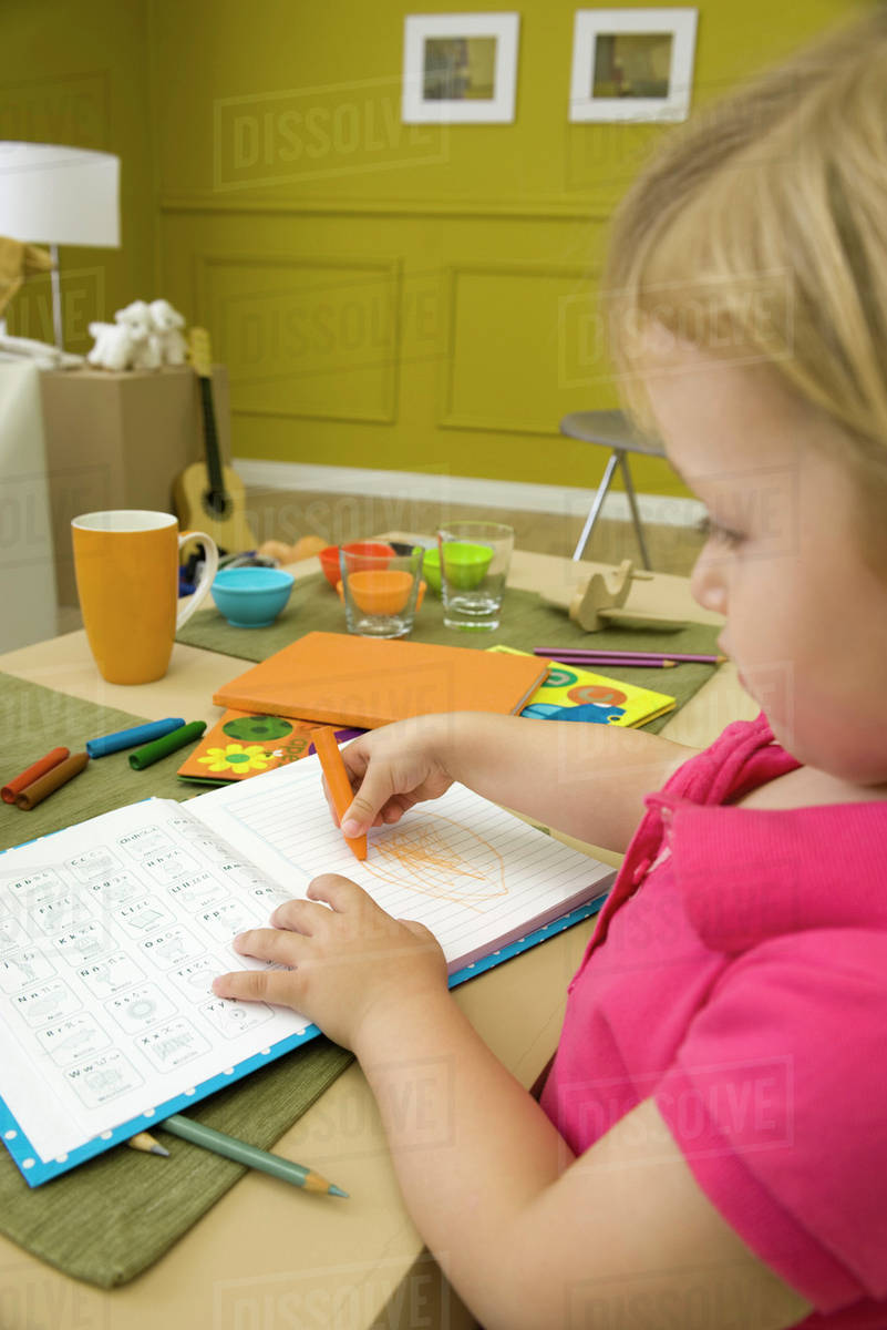 Little girl coloring at table, close-up - Stock Photo - Dissolve