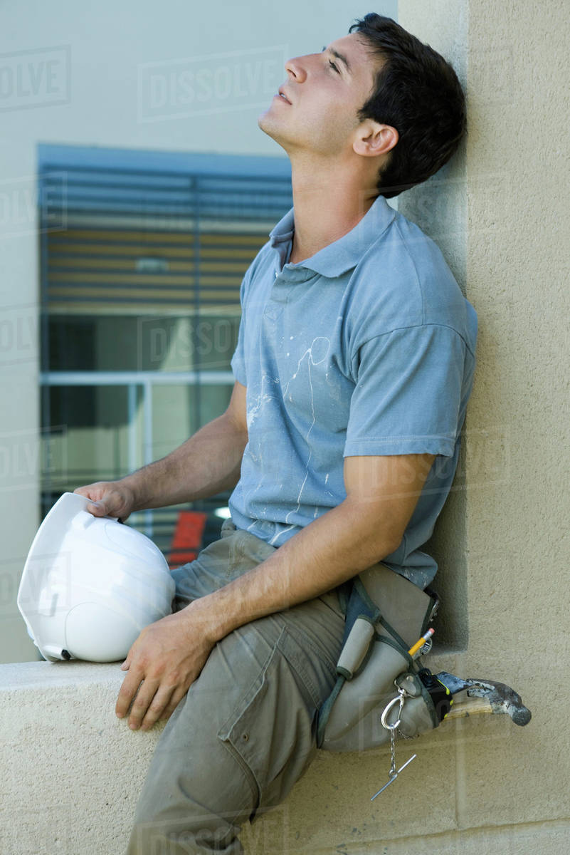 Man sitting on ledge, leaning head back, looking up - Stock Photo ...