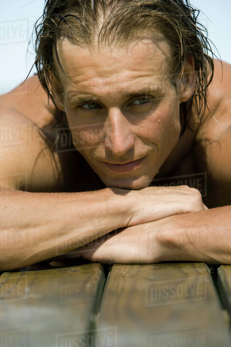 Man resting head on arms on side of pool - Royalty-free Stock Photo ...