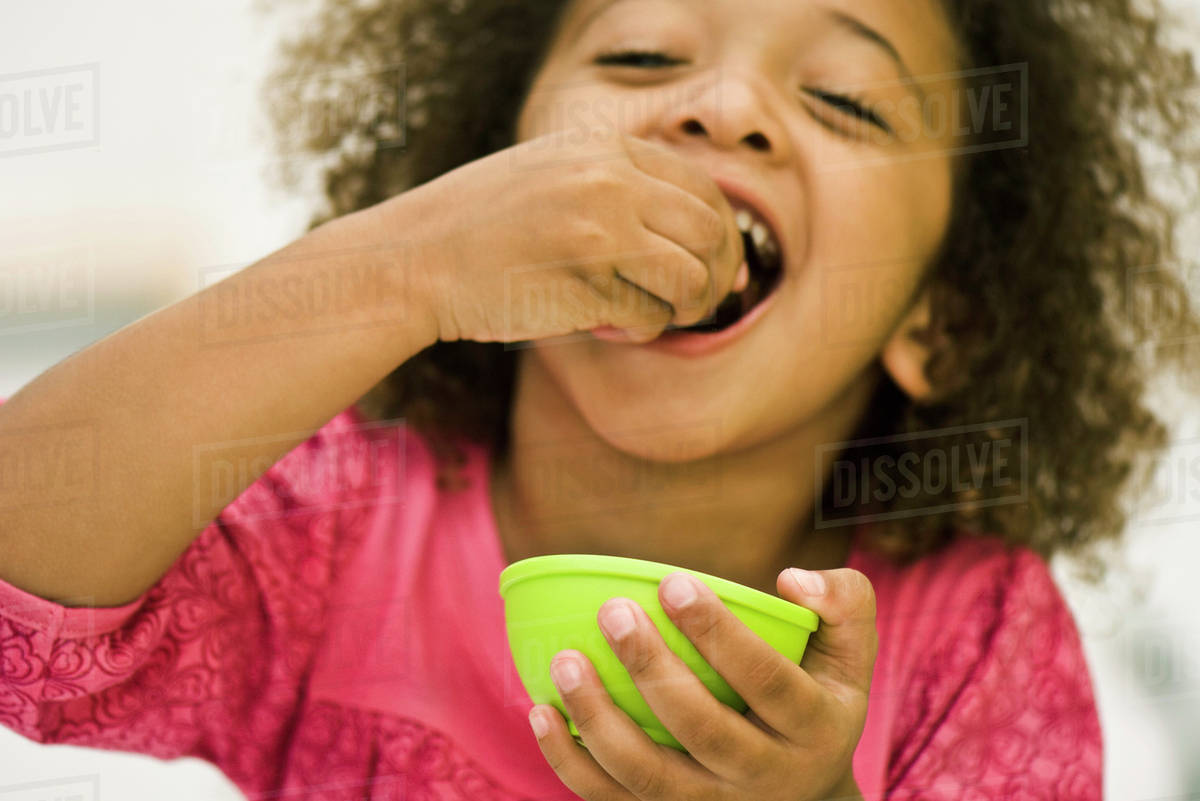 Little girl eating snack - Stock Photo - Dissolve