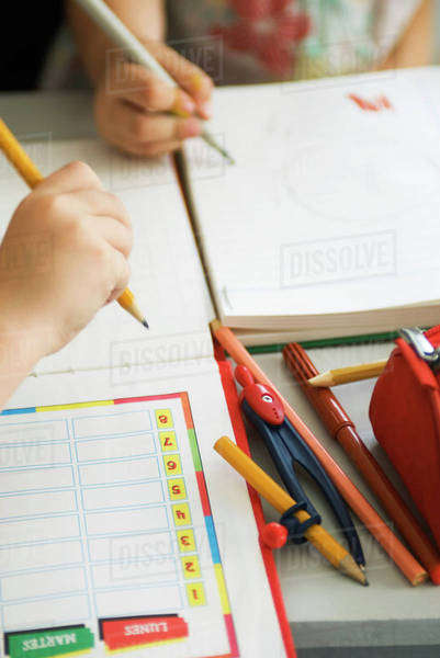 Children writing in notebooks, school supplies nearby, cropped - Stock ...