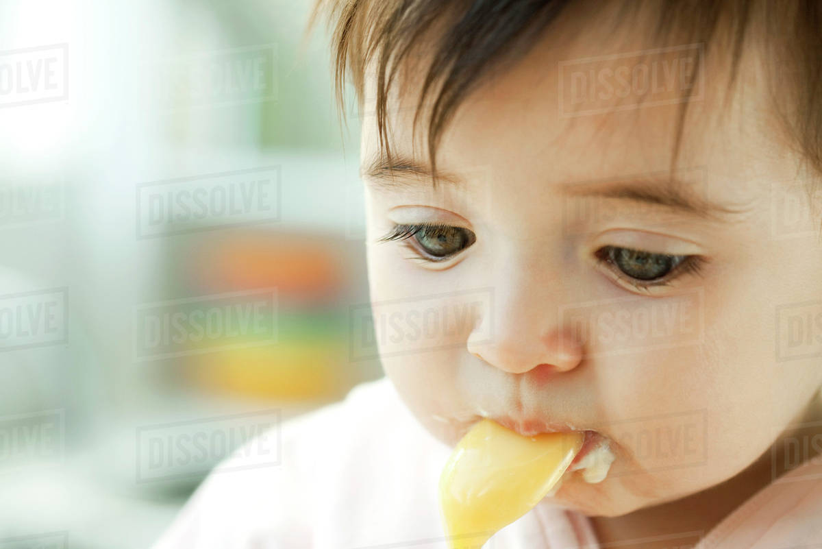 Infant eating with spoon - Royalty-free Stock Photo | Dissolve