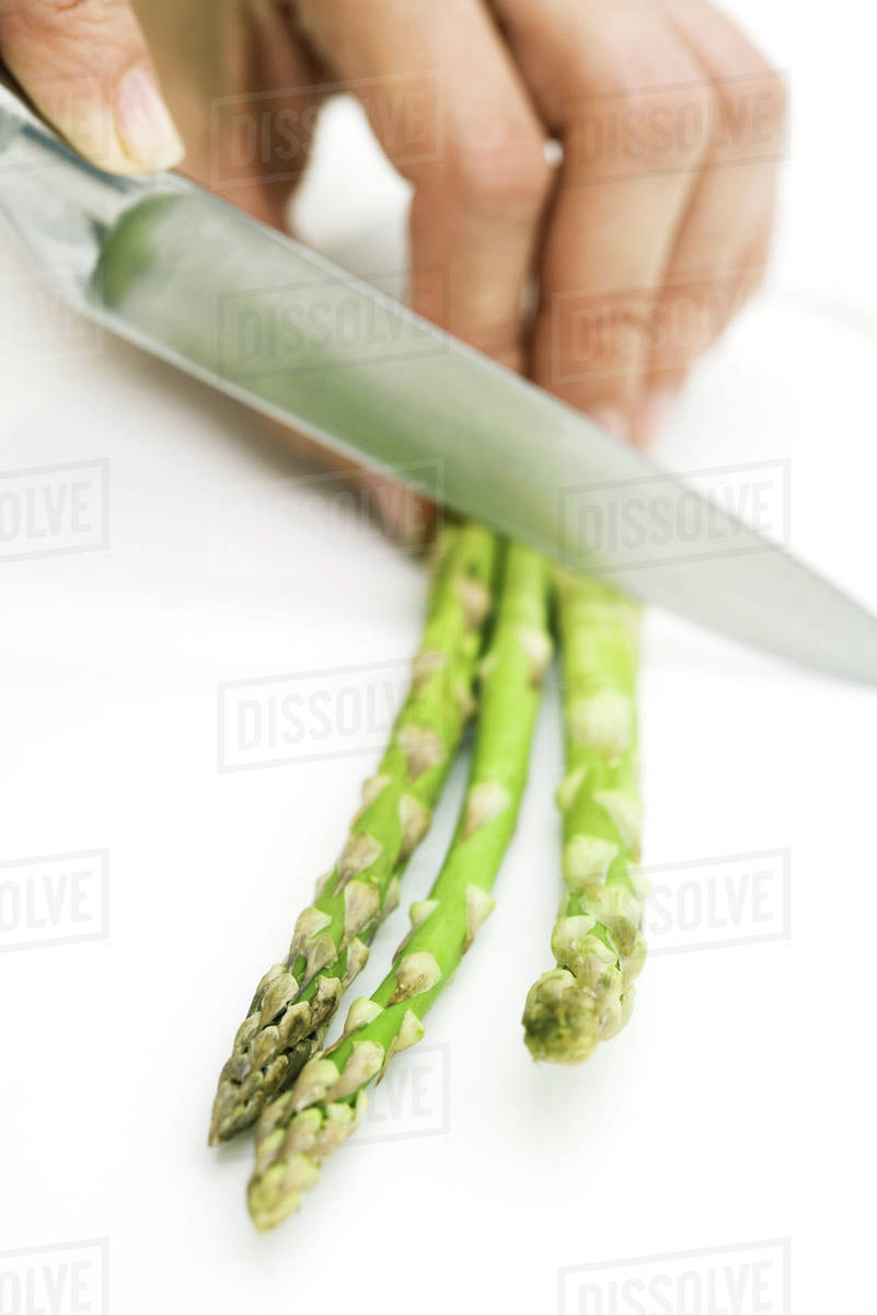 Woman cutting asparagus with knife, cropped view of hand - Royalty-free ...
