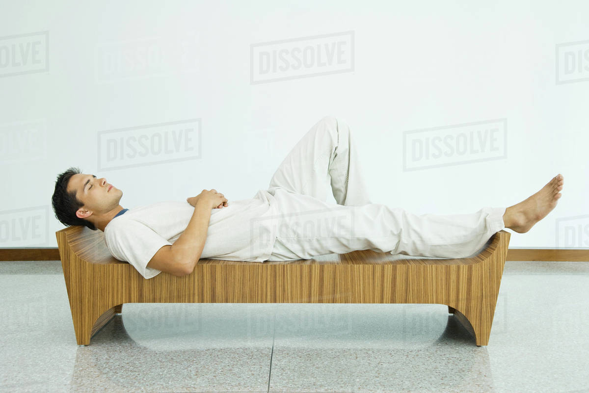 Man lying on bench with eyes closed, side view - Royalty-free Stock ...
