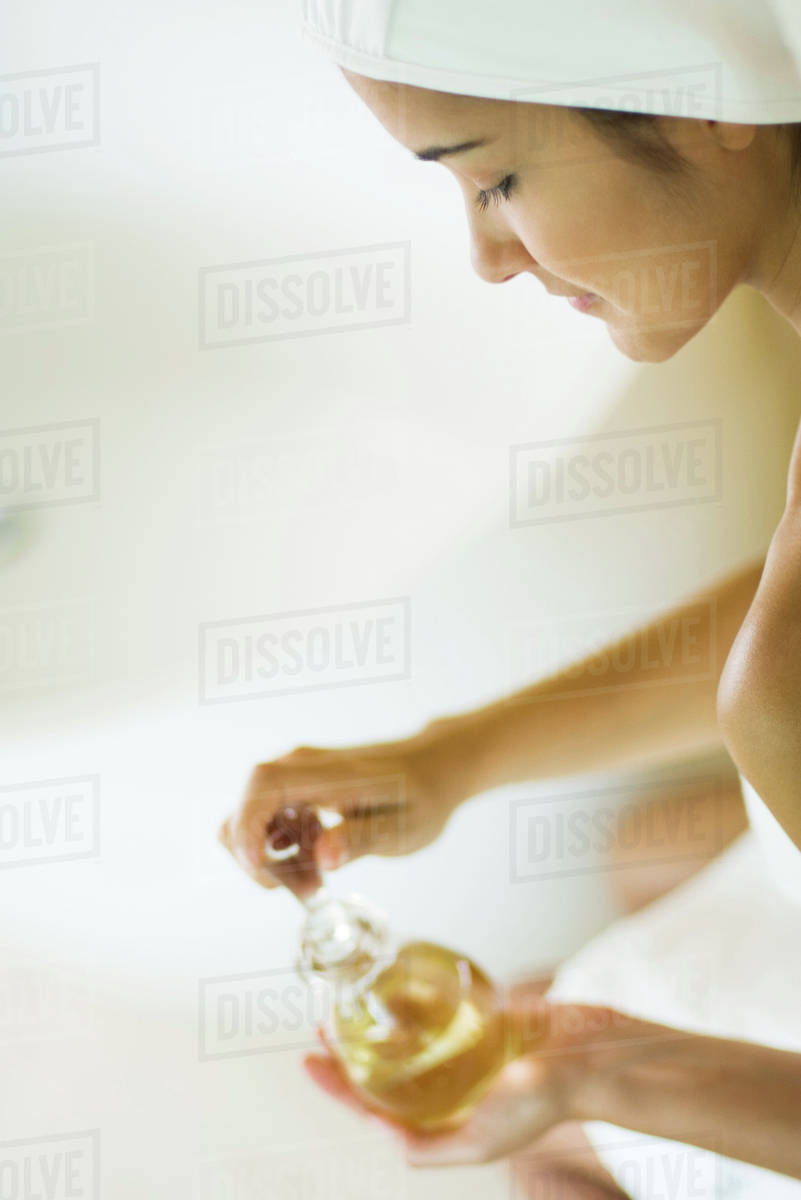 Woman opening perfume bottle, side view, high angle, cropped - Royalty ...