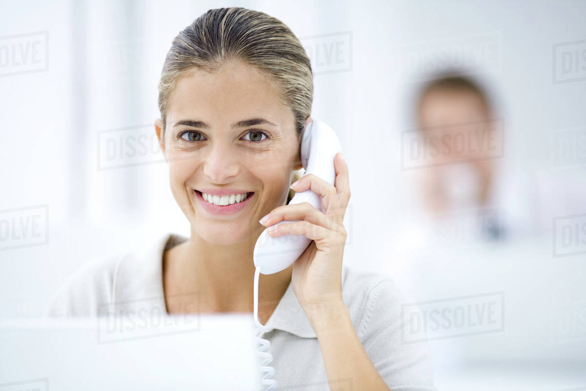 Young woman in office, using landline phone - Royalty-free Stock Photo ...