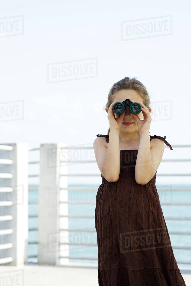 Girl looking through binoculars, standing on pier - Royalty-free Stock ...