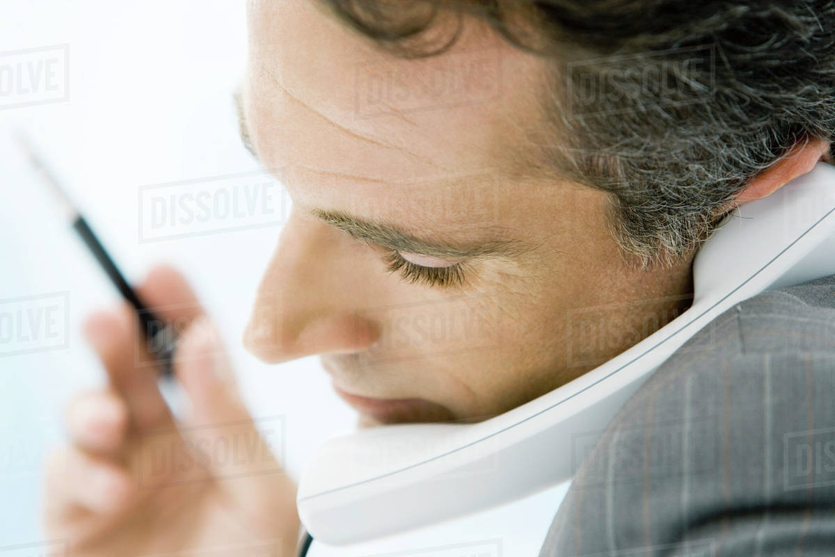 Man holding phone between chin and shoulder, side view, close-up ...