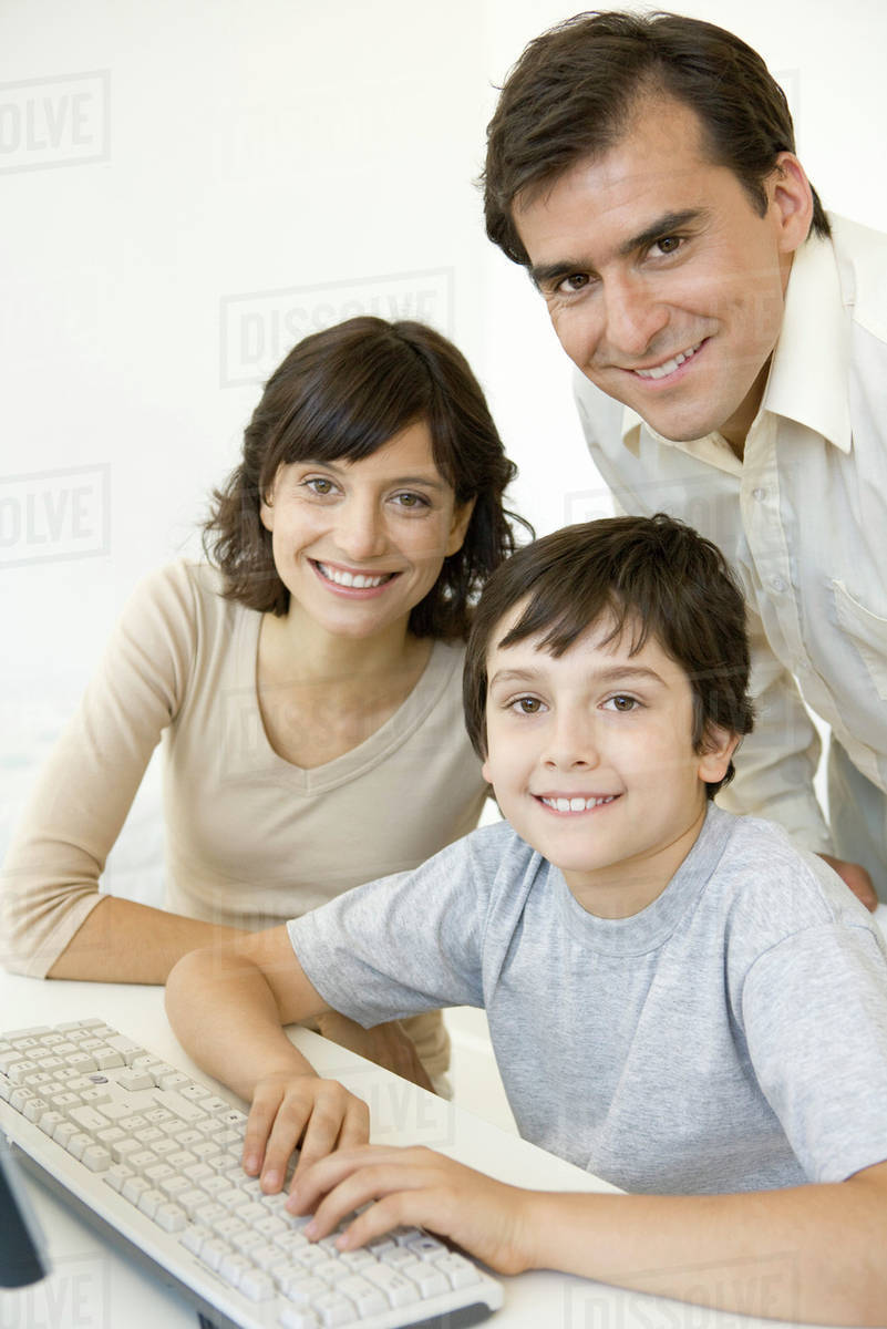 Boy with parents, using keyboard, all smiling at camera - Royalty-free ...