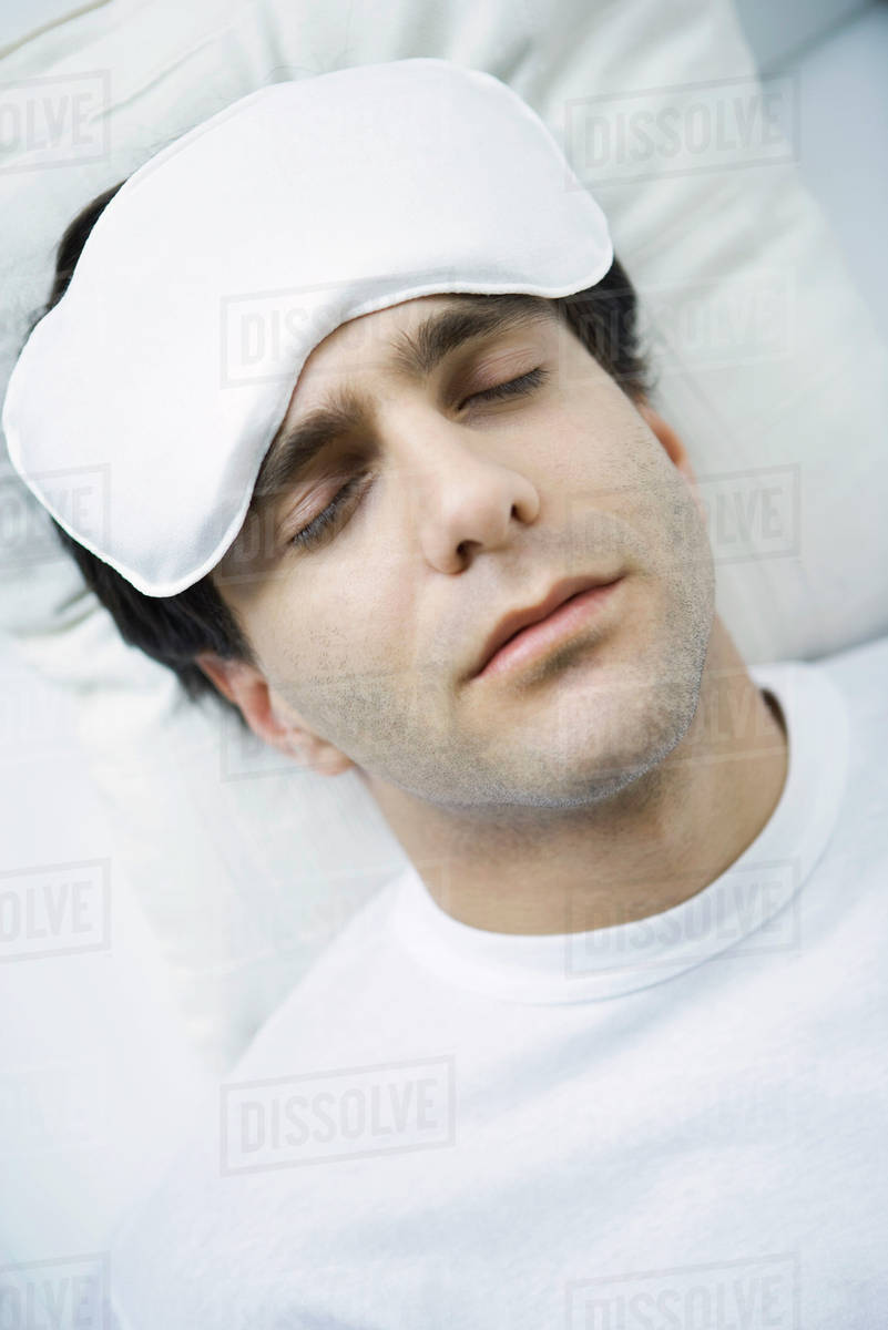 Man reclining with ice pack on his forehead, eyes closed - Stock Photo ...
