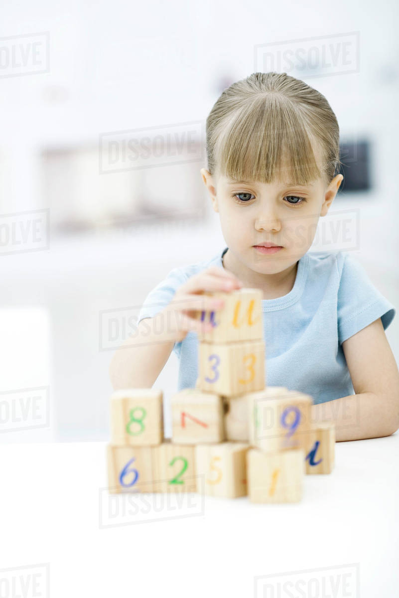 Little girl stacking blocks - Royalty-free Stock Photo | Dissolve
