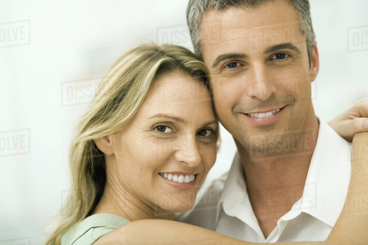 Couple smiling at camera, woman wrapping arms around man, portrait ...