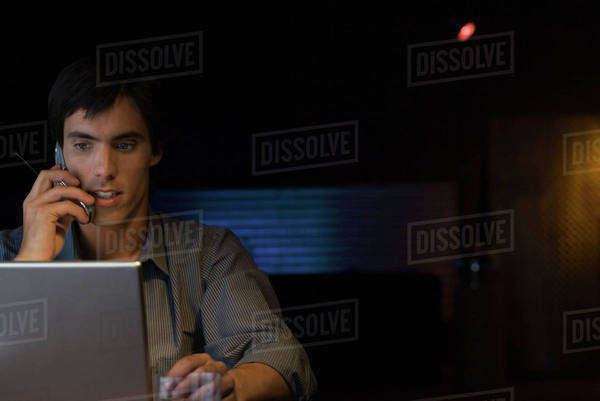 Man talking on cell phone, using laptop computer - Royalty-free Stock ...