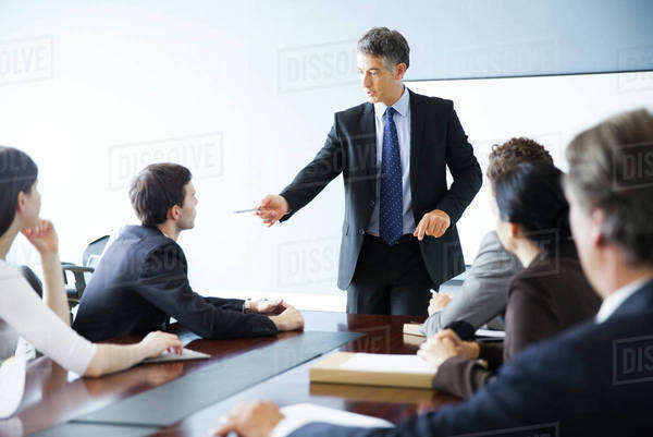 Business executive giving presentation at meeting - Stock Photo - Dissolve