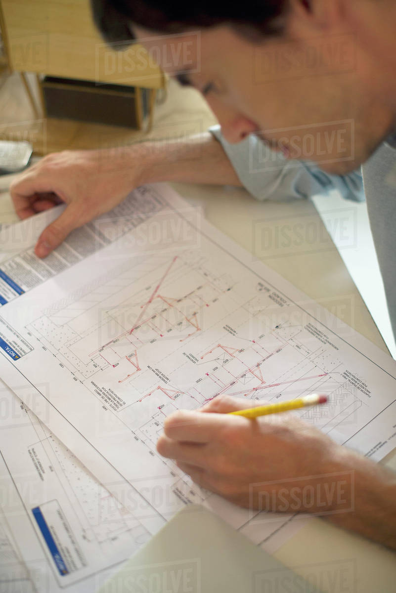 Architect examining blueprint - Royalty-free Stock Photo | Dissolve