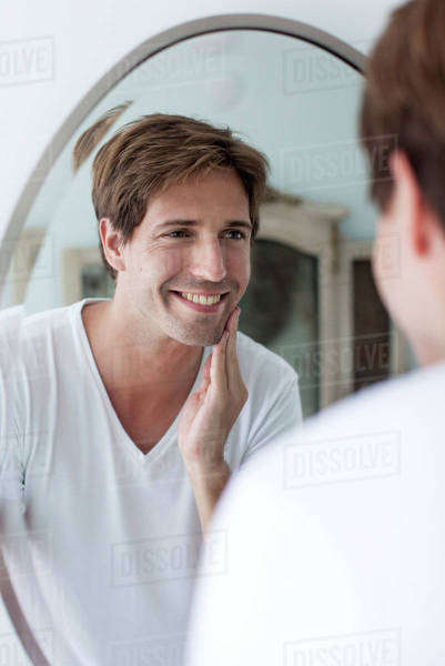 Man looking at self in mirror admiring facial stubble - Royalty-free ...