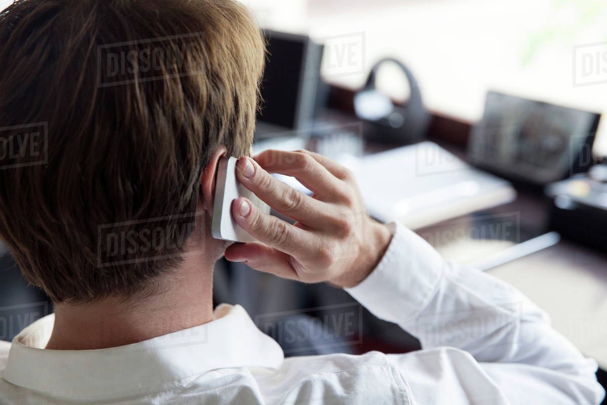 Man using cell phone, rear view - Royalty-free Stock Photo | Dissolve