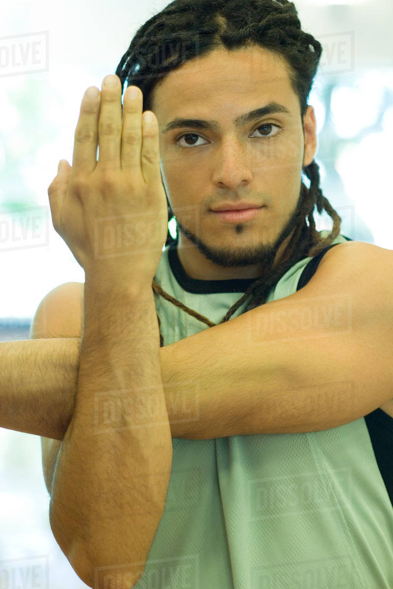 Man doing arm stretch, portrait - Royalty-free Stock Photo | Dissolve