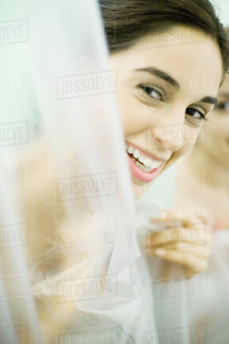 Woman looking at camera from behind shower - Stock Photo - Dissolve