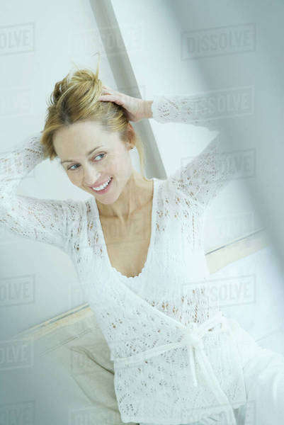 Woman holding hair back, smiling - Royalty-free Stock Photo | Dissolve