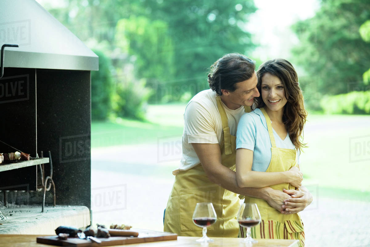 Couple having cookout, man hugging woman from behind - Royalty-free ...