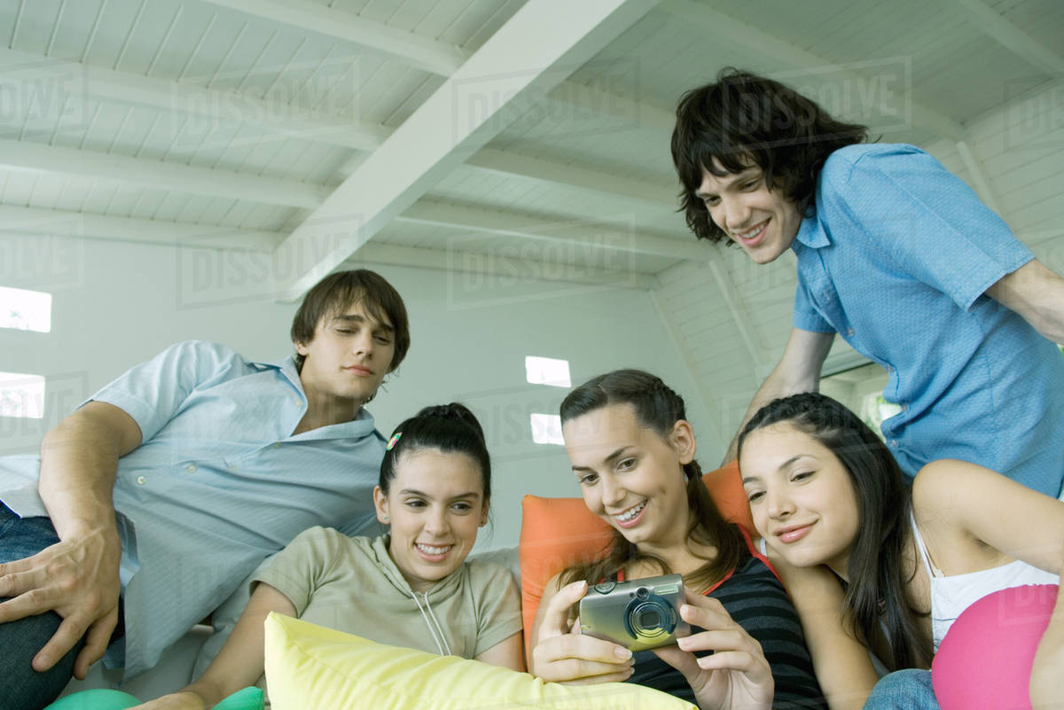 Teenage friends looking at digital camera together - Royalty-free Stock ...