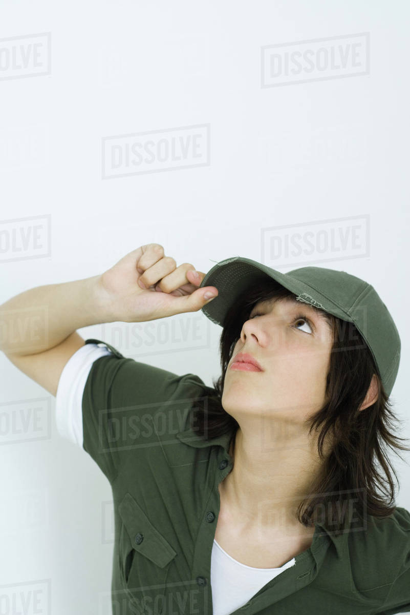 Teenage boy adjusting cap, looking up - Royalty-free Stock Photo | Dissolve
