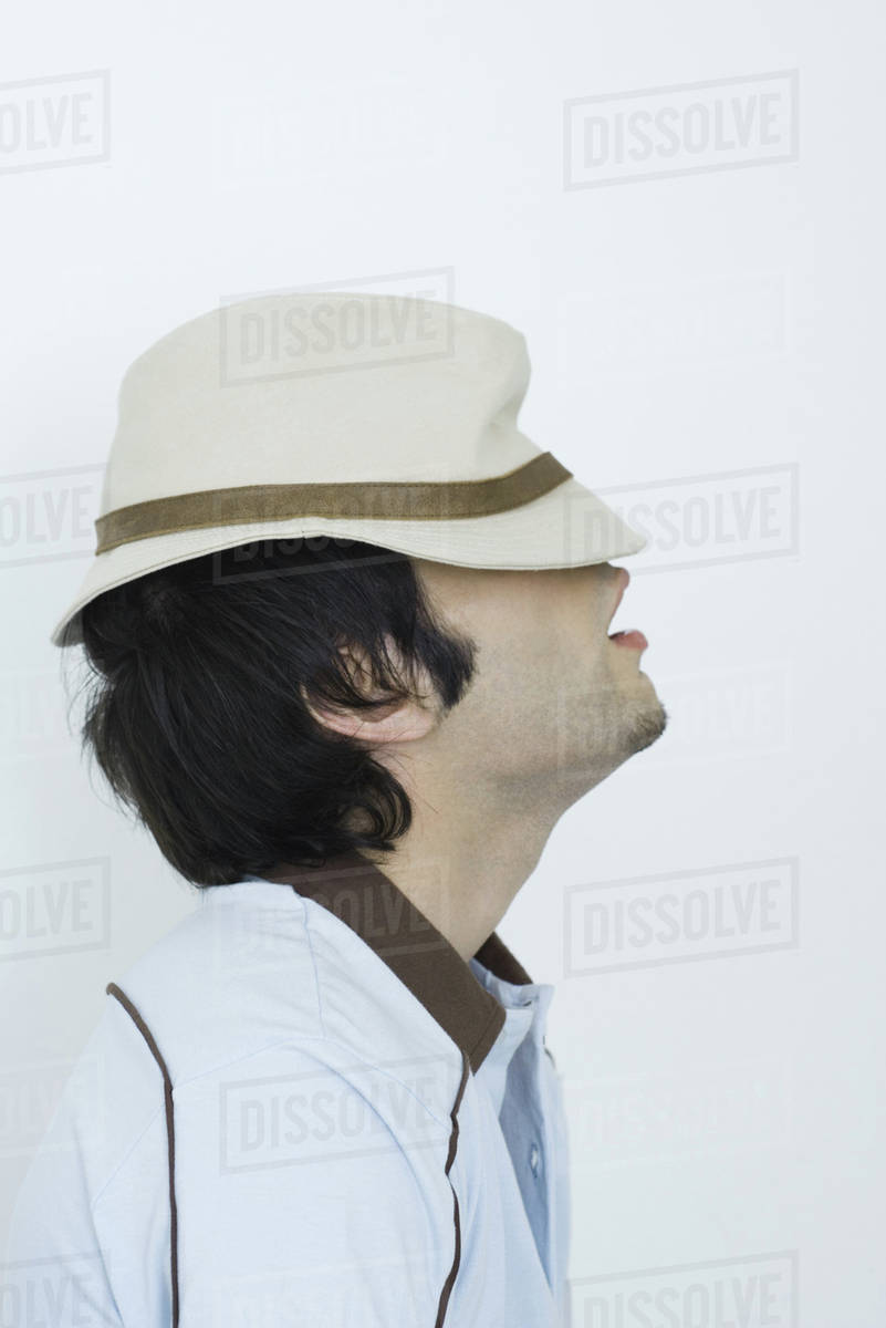 Young man wearing hat pulled down over eyes, side view - Royalty-free ...