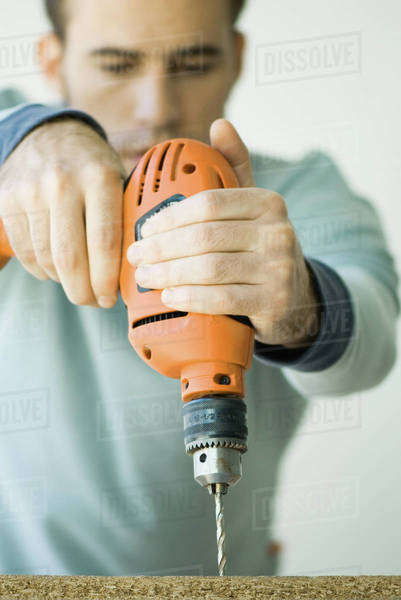 Man using drill - Stock Photo - Dissolve