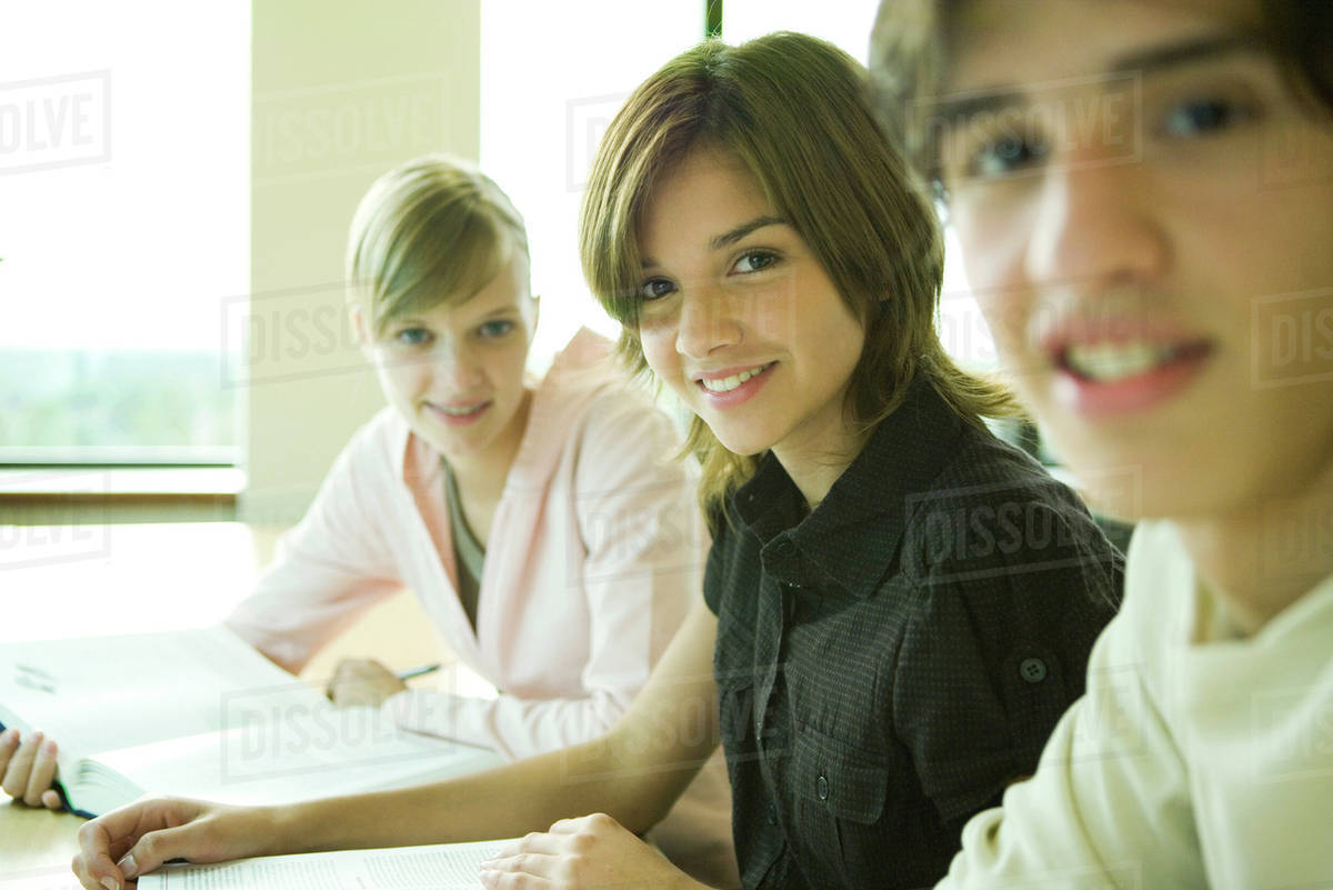 College students sitting at table, smiling at camera - Stock Photo ...
