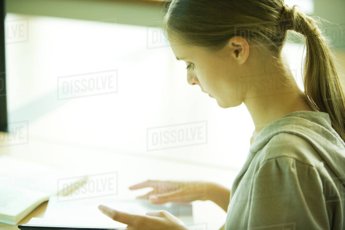 Female college student sitting at table in library, studying - Stock ...