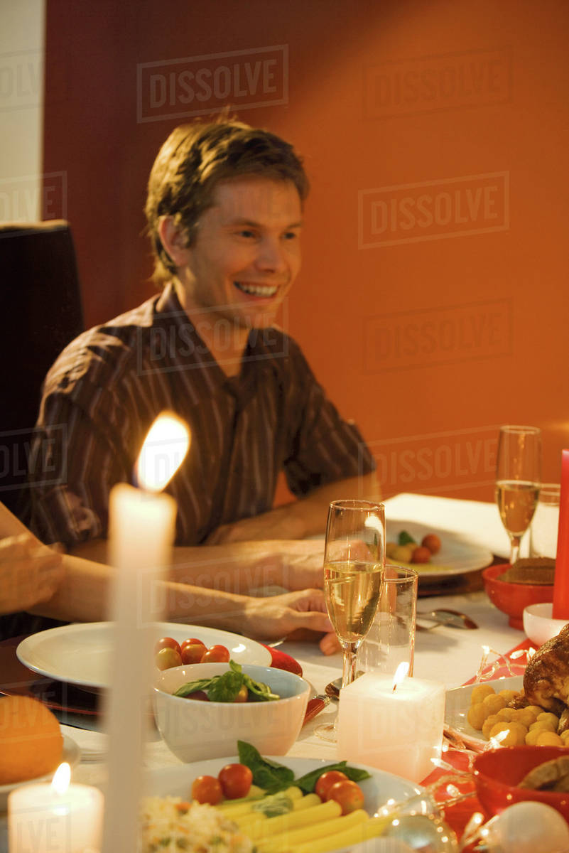 Man sitting at dinner table, smiling - Royalty-free Stock Photo | Dissolve